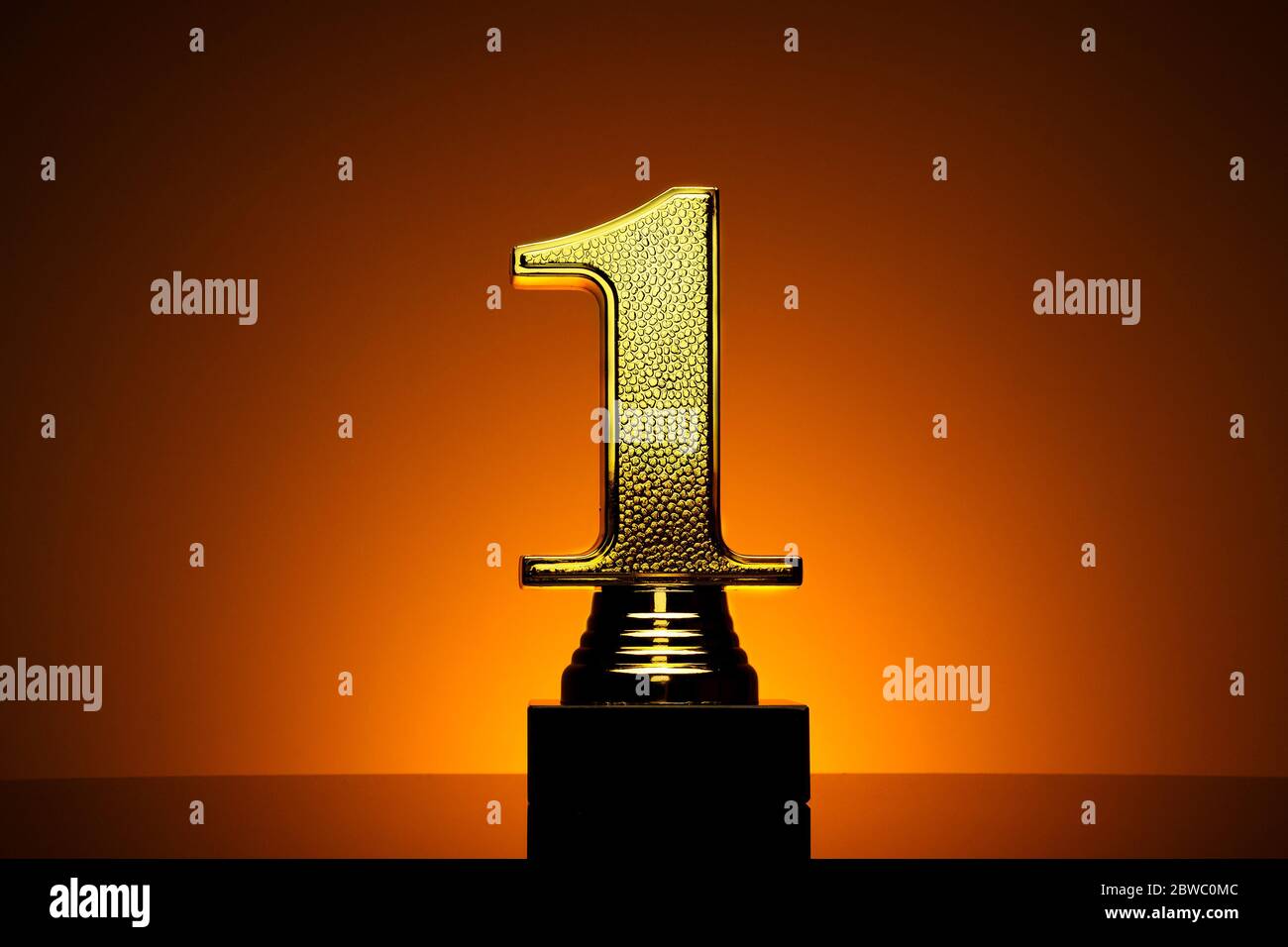 Gold number one trophy on a plinth for the winner of a competition or ...