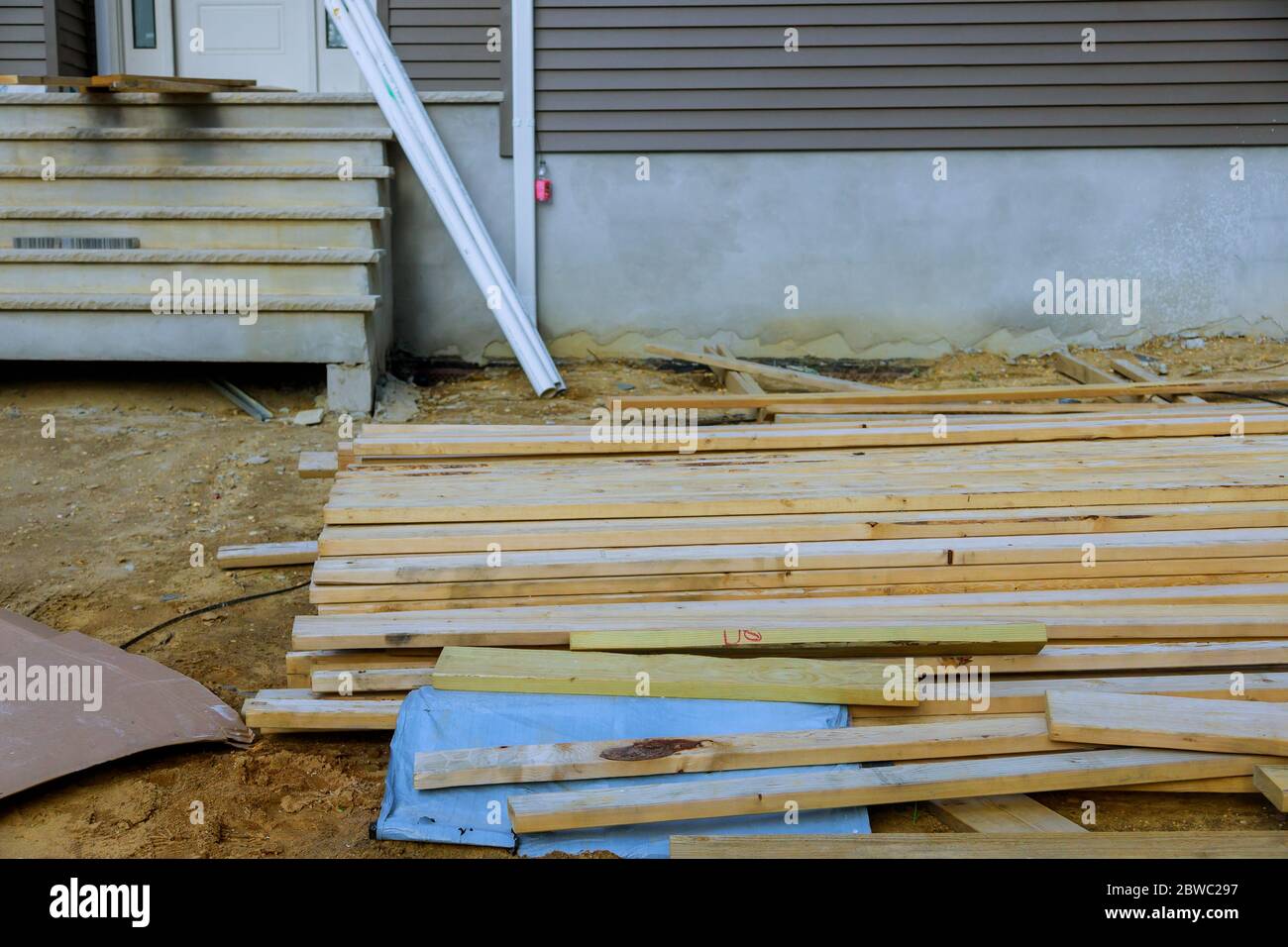 House under construction of stack unloading wooden beams on ...