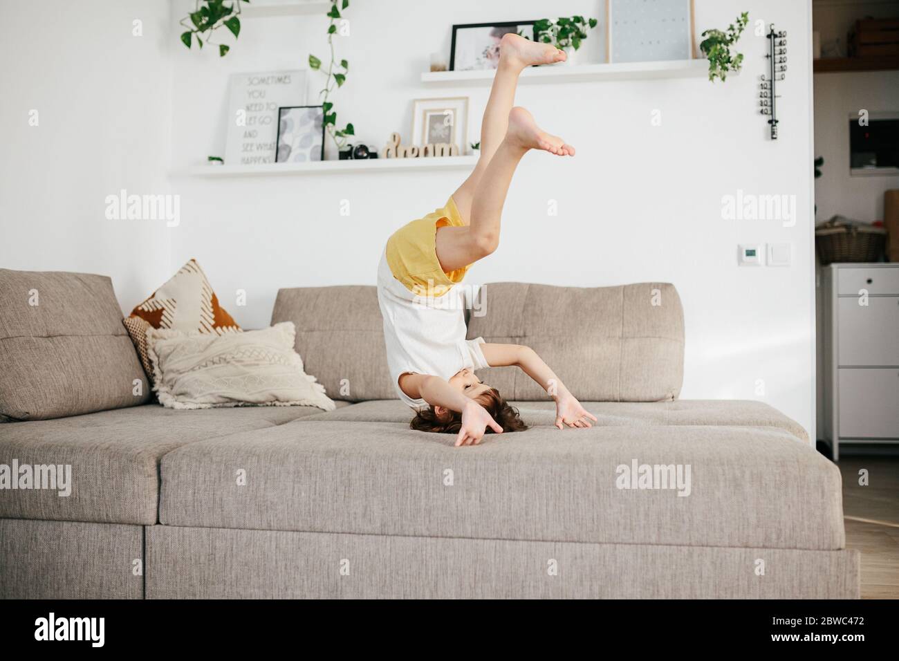 Beautiful little toddler tumbling on sofa at home. Child Learn To ...