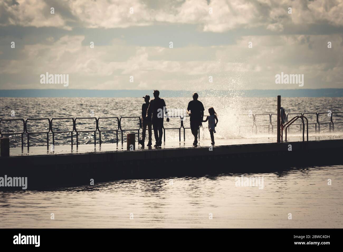 Group of people walking on a pier during the storm Stock Photo - Alamy