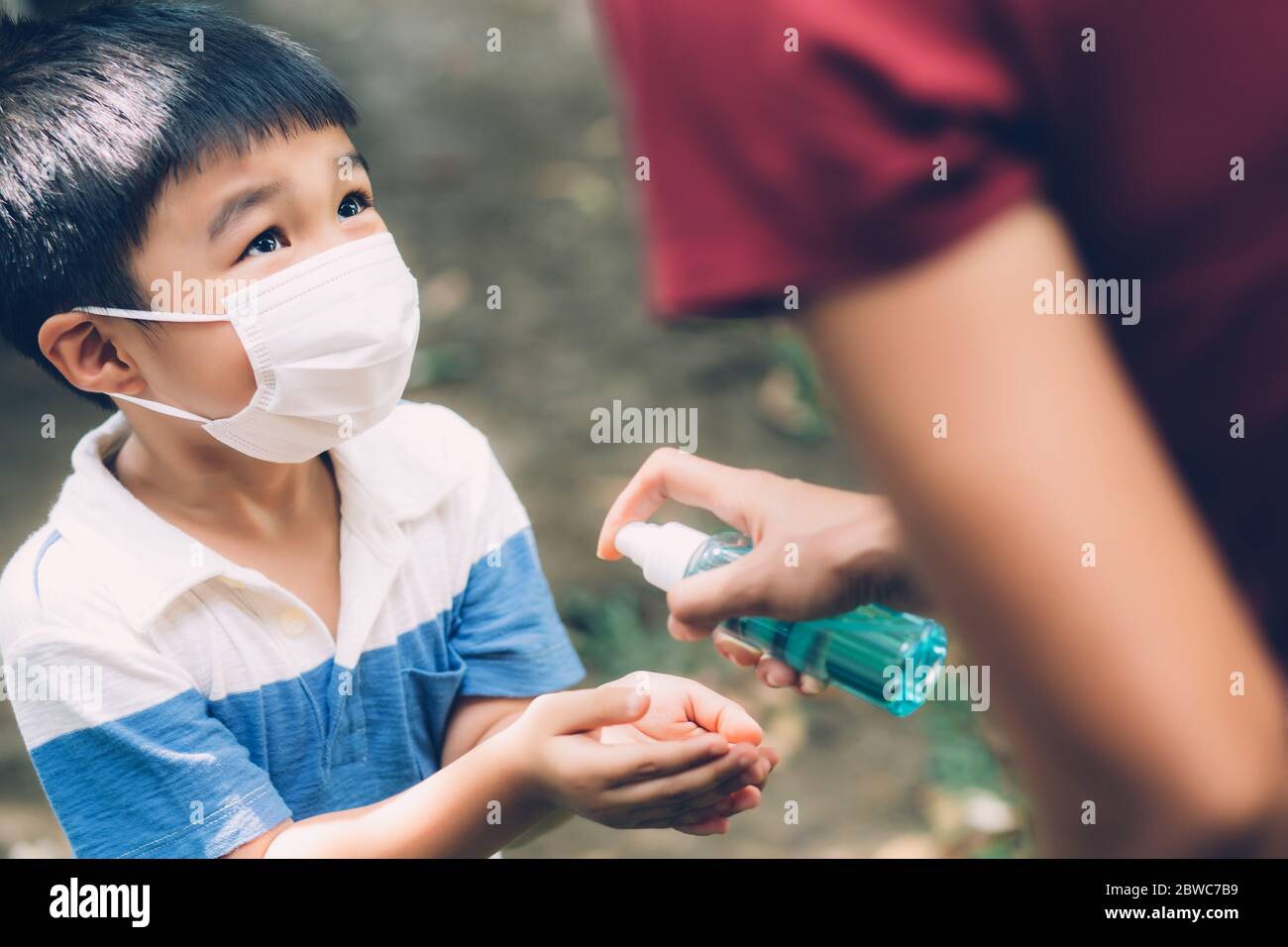 Mother take care son with face mask and sanitizer for protection ...