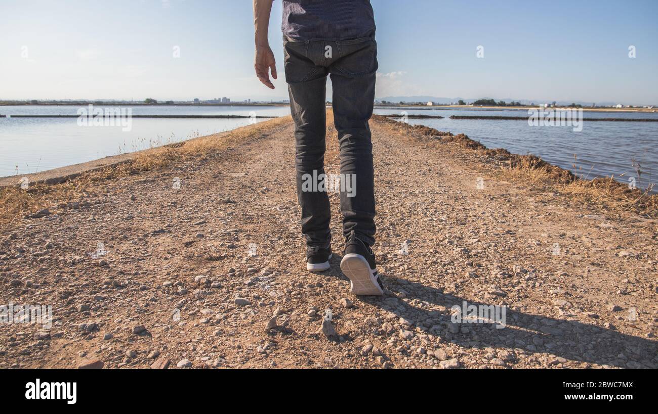 Man walking back to back on a path Stock Photo - Alamy
