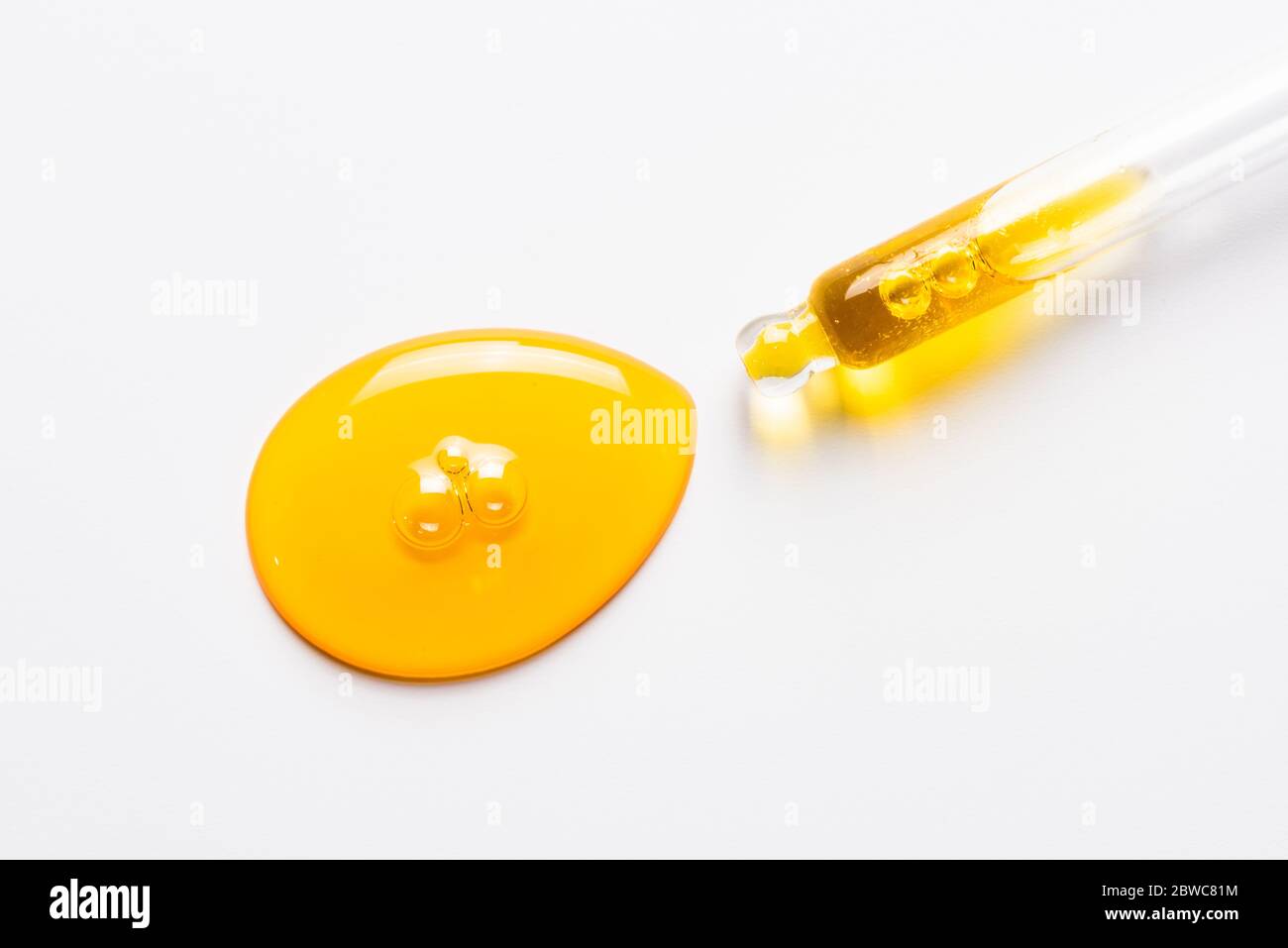 Cosmetic dropper with yellow oil. Anti-aging serum on white Stock Photo ...