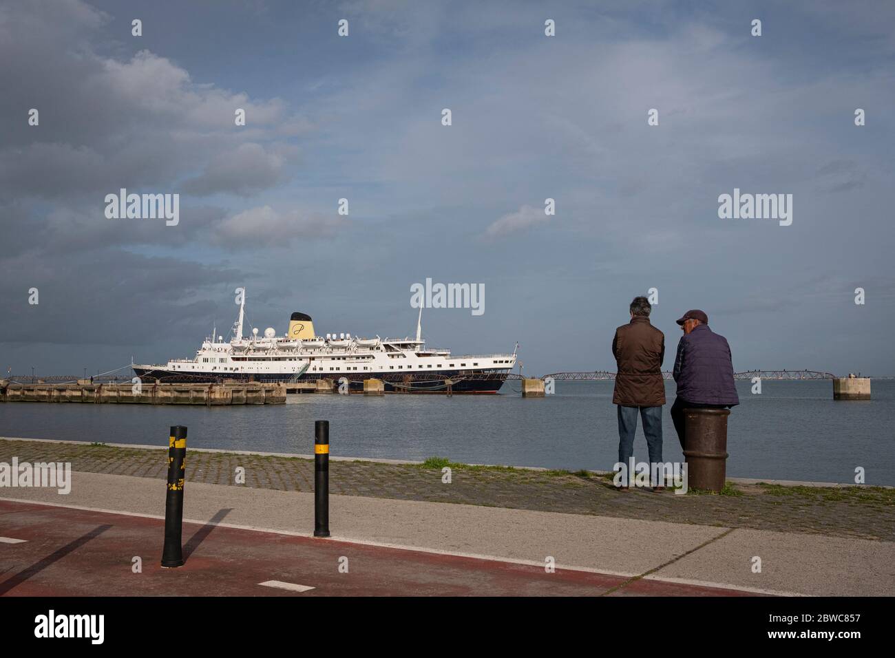 Lisbon, Portugal - 29 February 2020 : Two men talking by the Tejo river ...