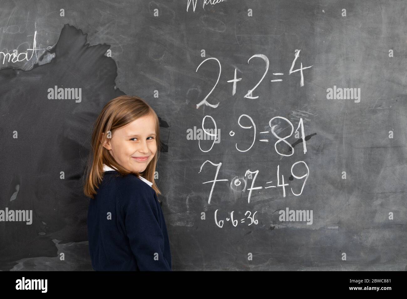 Schoolgirl at the blackboard. Shows the results of math problems ...