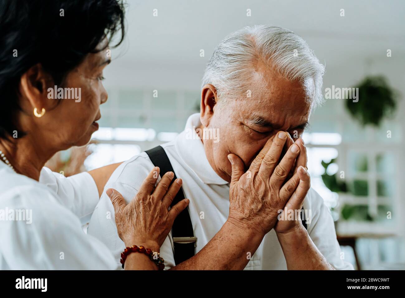 Unhappy Retired Asian Senior Couple Sitting On The Sofa While Elderly