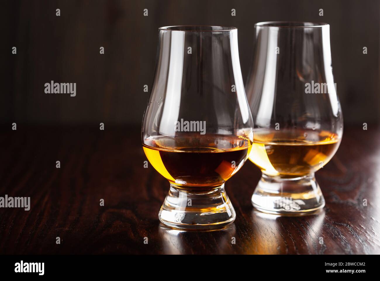 glass of whisky spirit brandy on dark brown background Stock Photo - Alamy