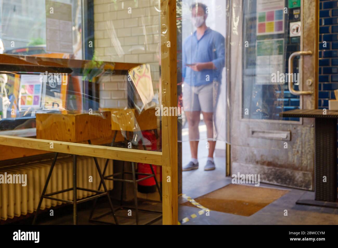 Temporary transparent plastic partition set up on wooden frame to ...