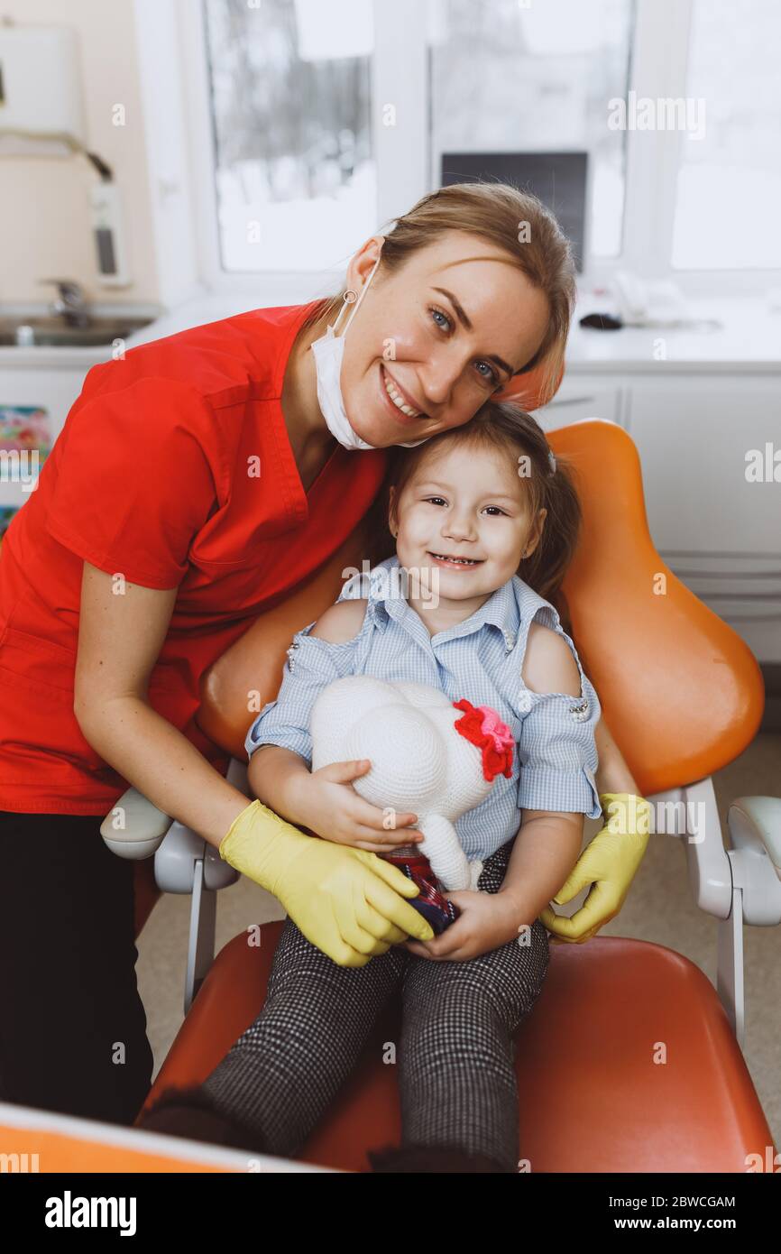 High angle of cheerful female dentist smiling and looking at camera ...