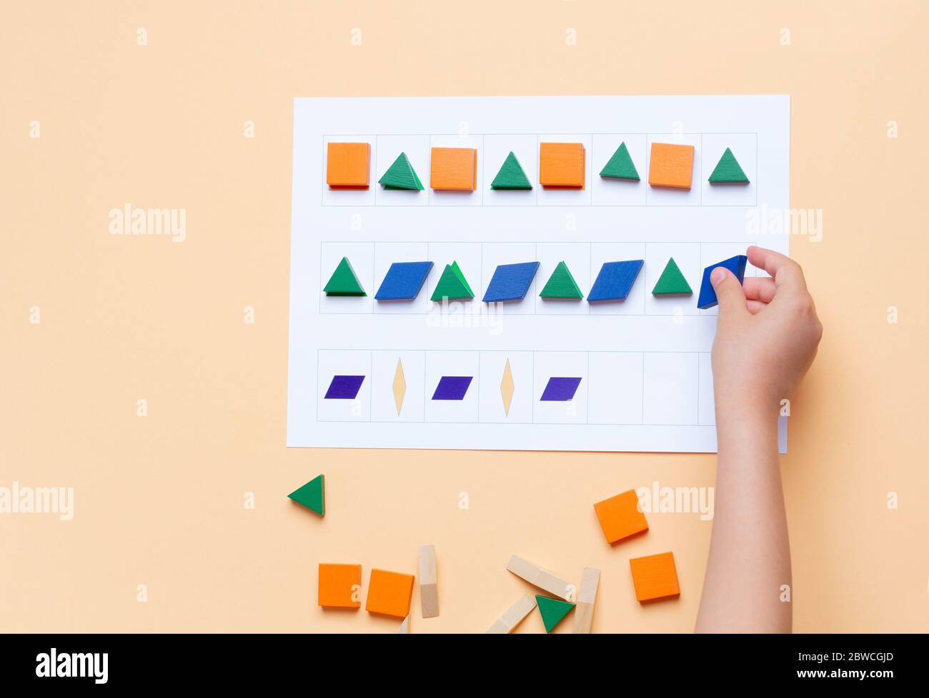 The child arranges blocks of various shapes according to the pattern ...
