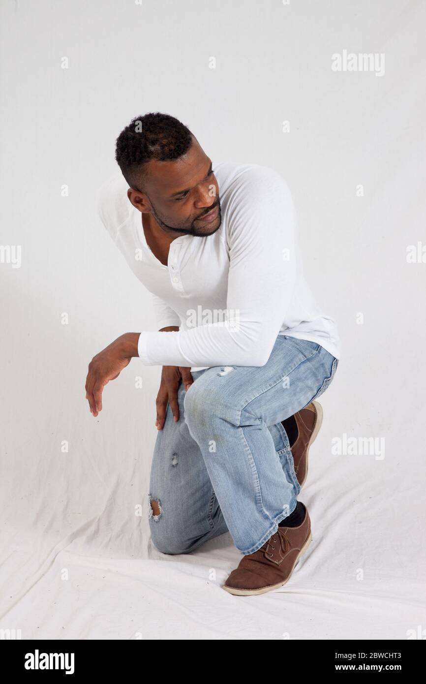 Pensive Black man kneeling Stock Photo - Alamy