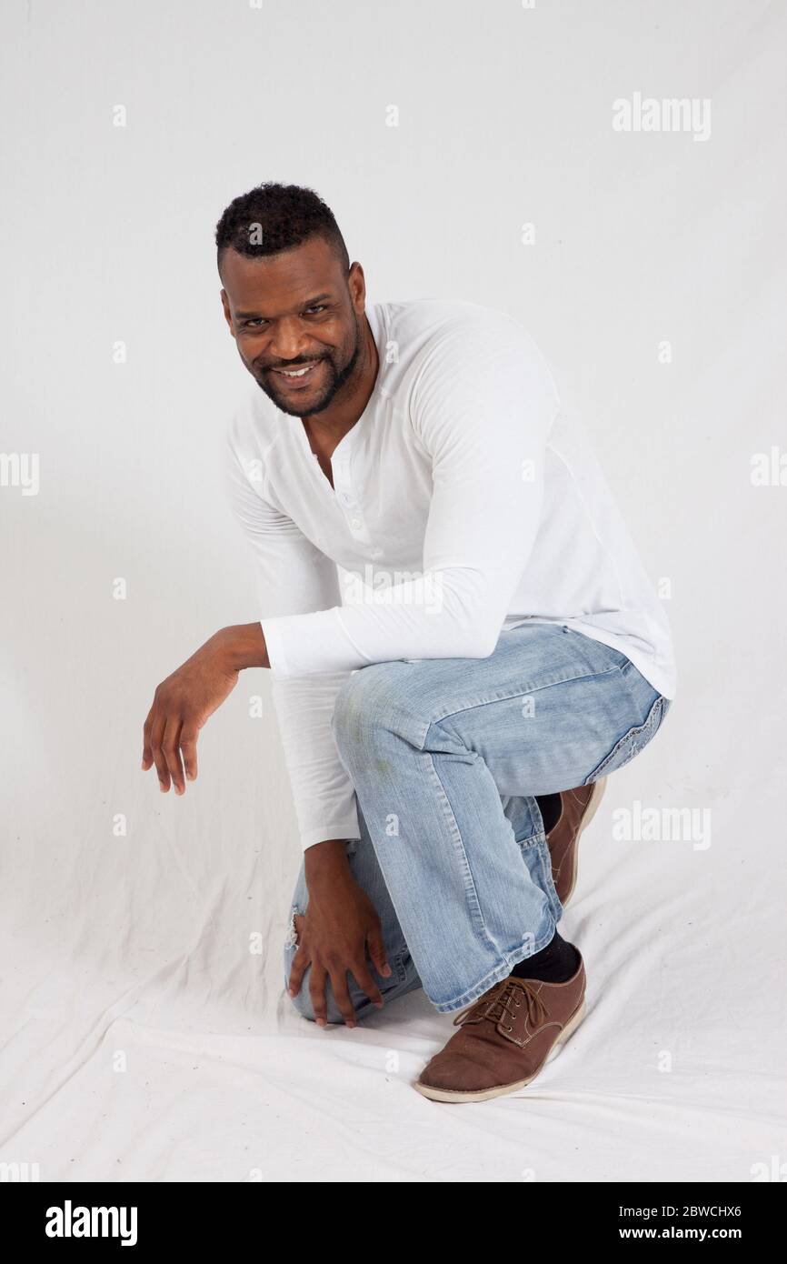 Happy Black man kneeling Stock Photo - Alamy
