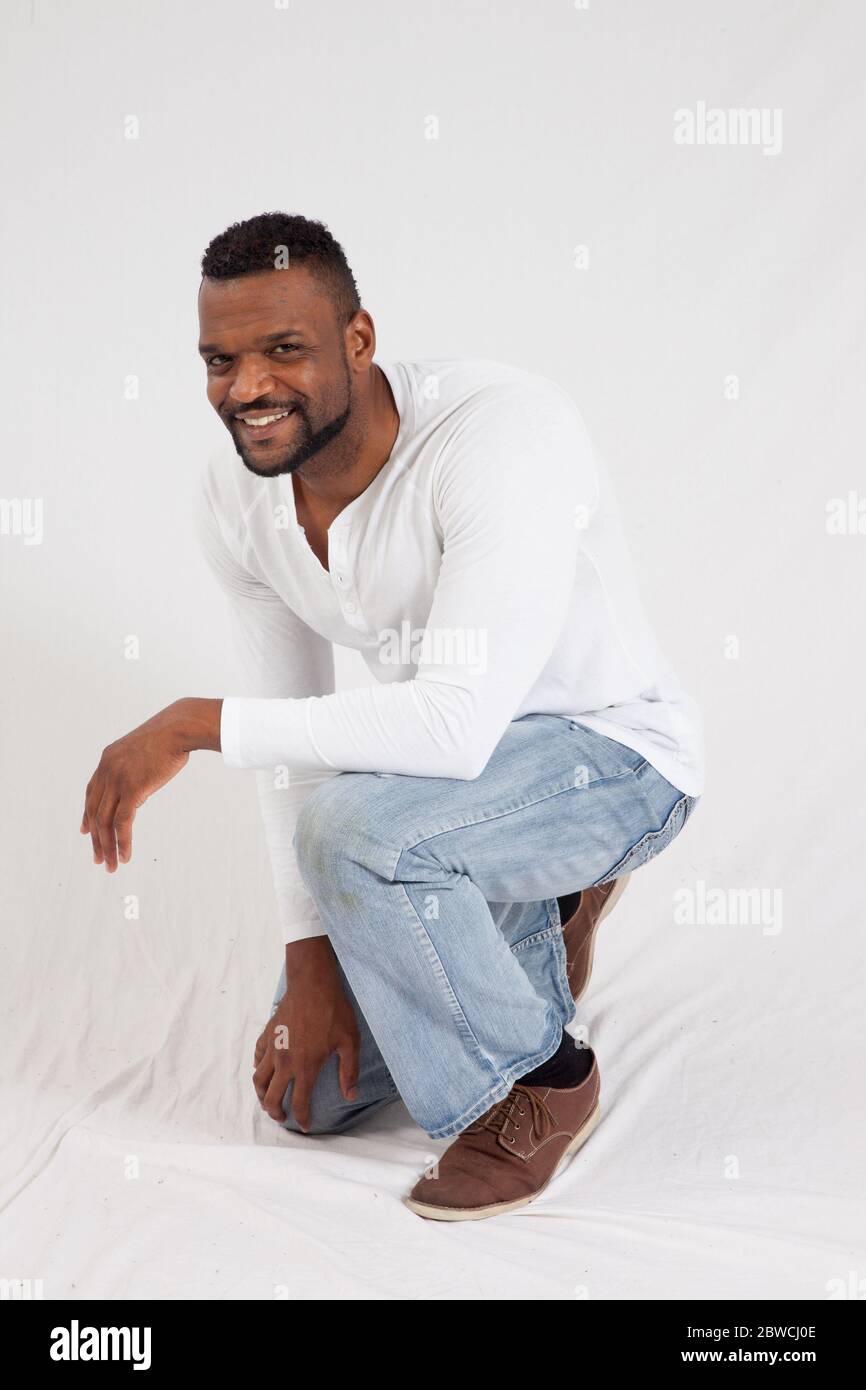 Happy Black man kneeling Stock Photo - Alamy