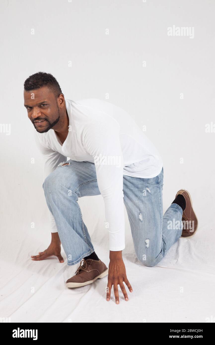 Happy Black man kneeling Stock Photo - Alamy
