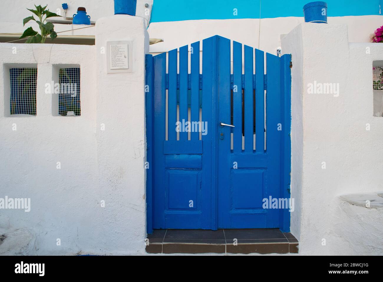 Traditional aegean blue house gate between white walls Stock Photo - Alamy