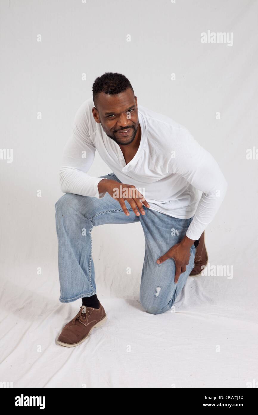 Pensive Black man kneeling Stock Photo - Alamy