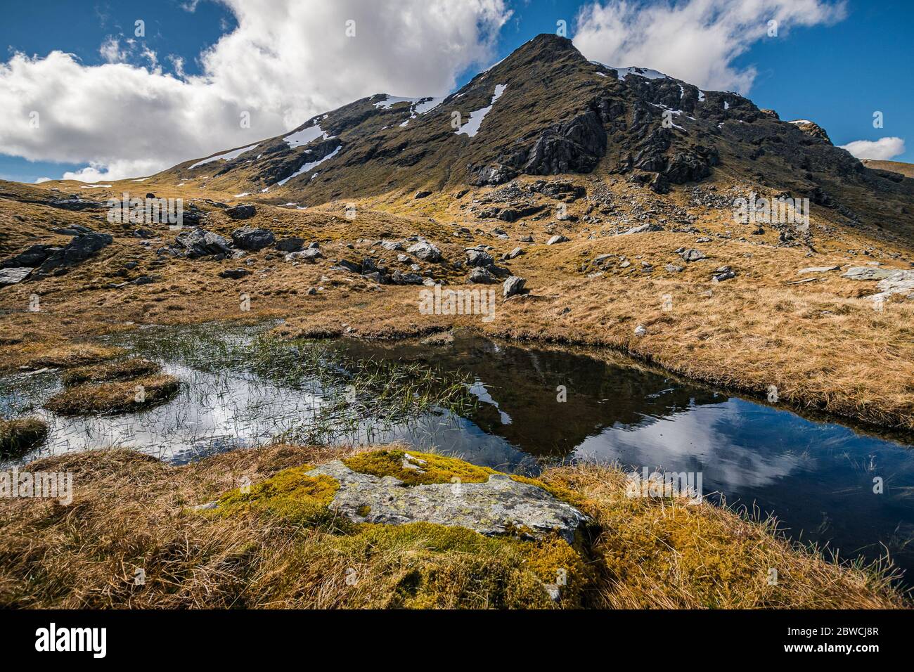 Mountain reflecting in a small pond on the ascent up Beinn Dorain in ...