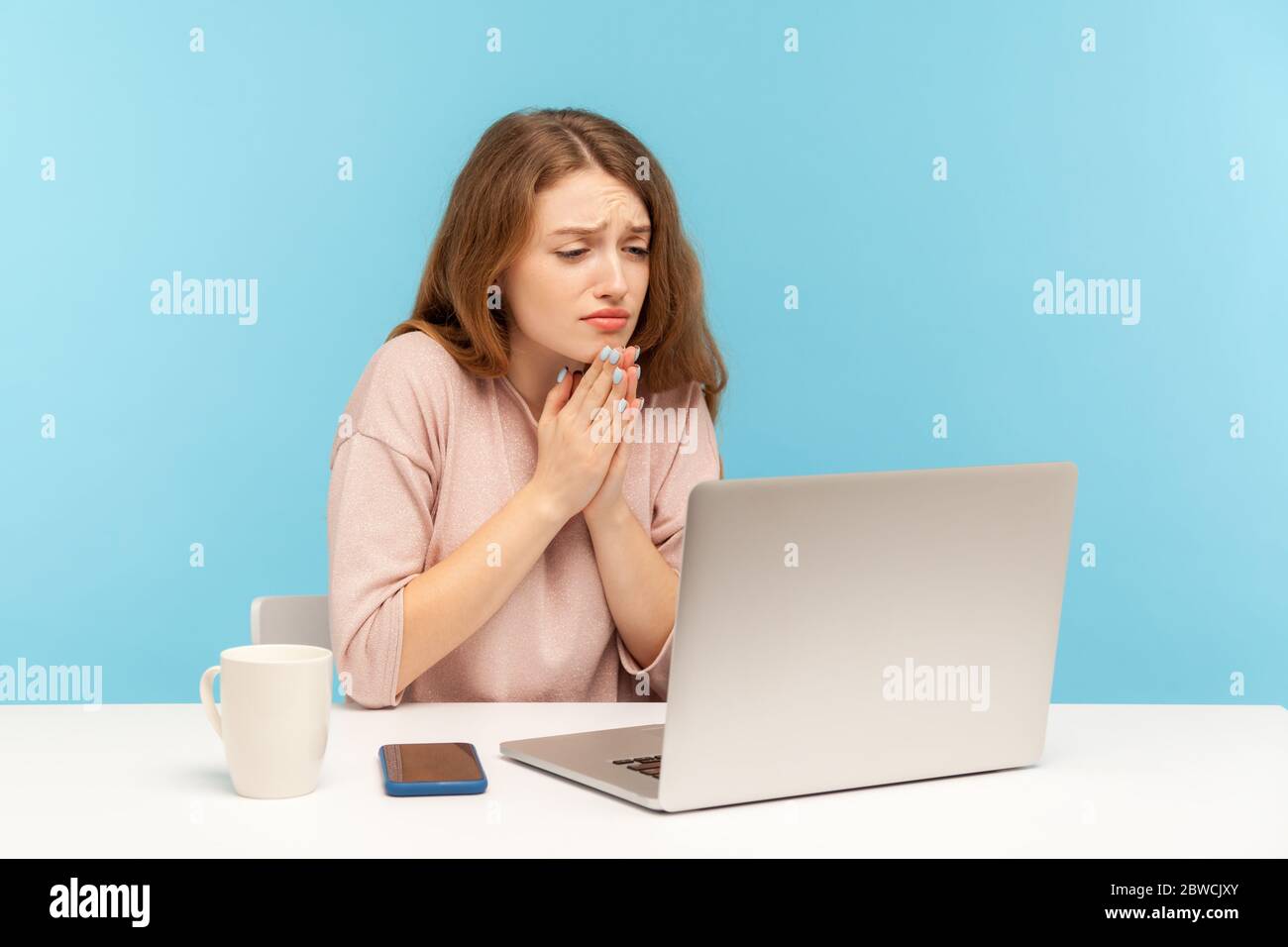 Please, begging for help! Young woman employee holding hands in praying ...