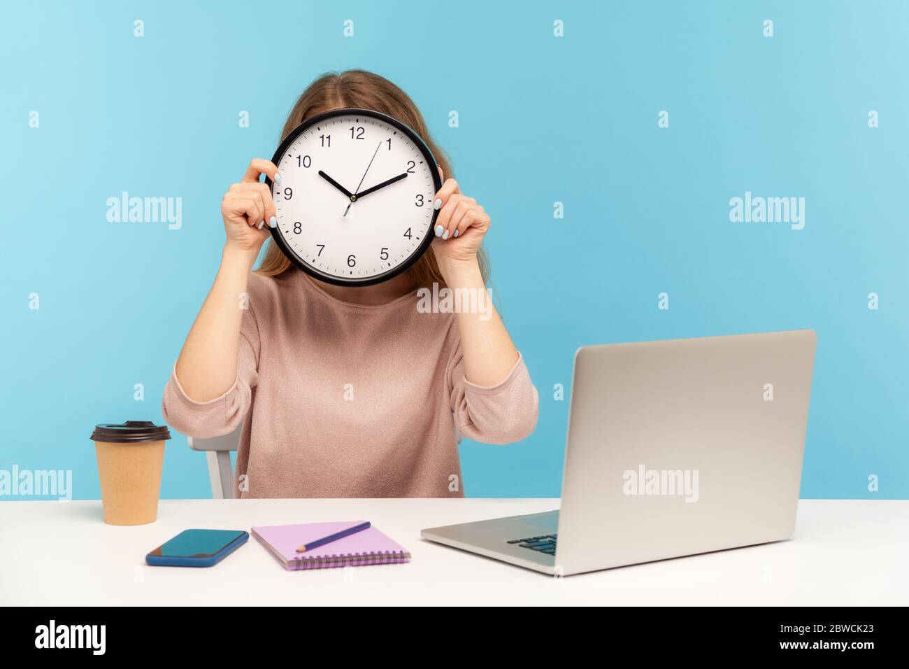 Time to work! Woman office employee sitting at workplace and covering ...