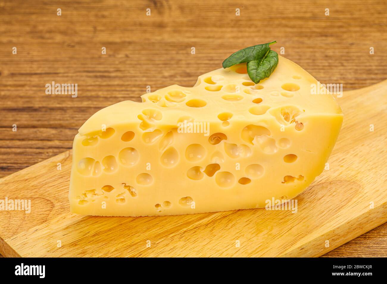 Maasdam cheese - dairy yellow triangle with holes Stock Photo - Alamy