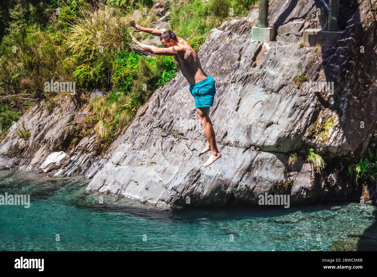 Young man jumping from bridge into the water hi-res stock photography ...