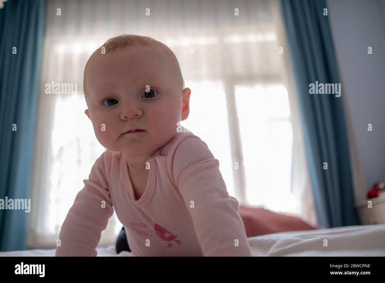 Cute baby girl standing on bed make funny faces, angry face, crying in ...
