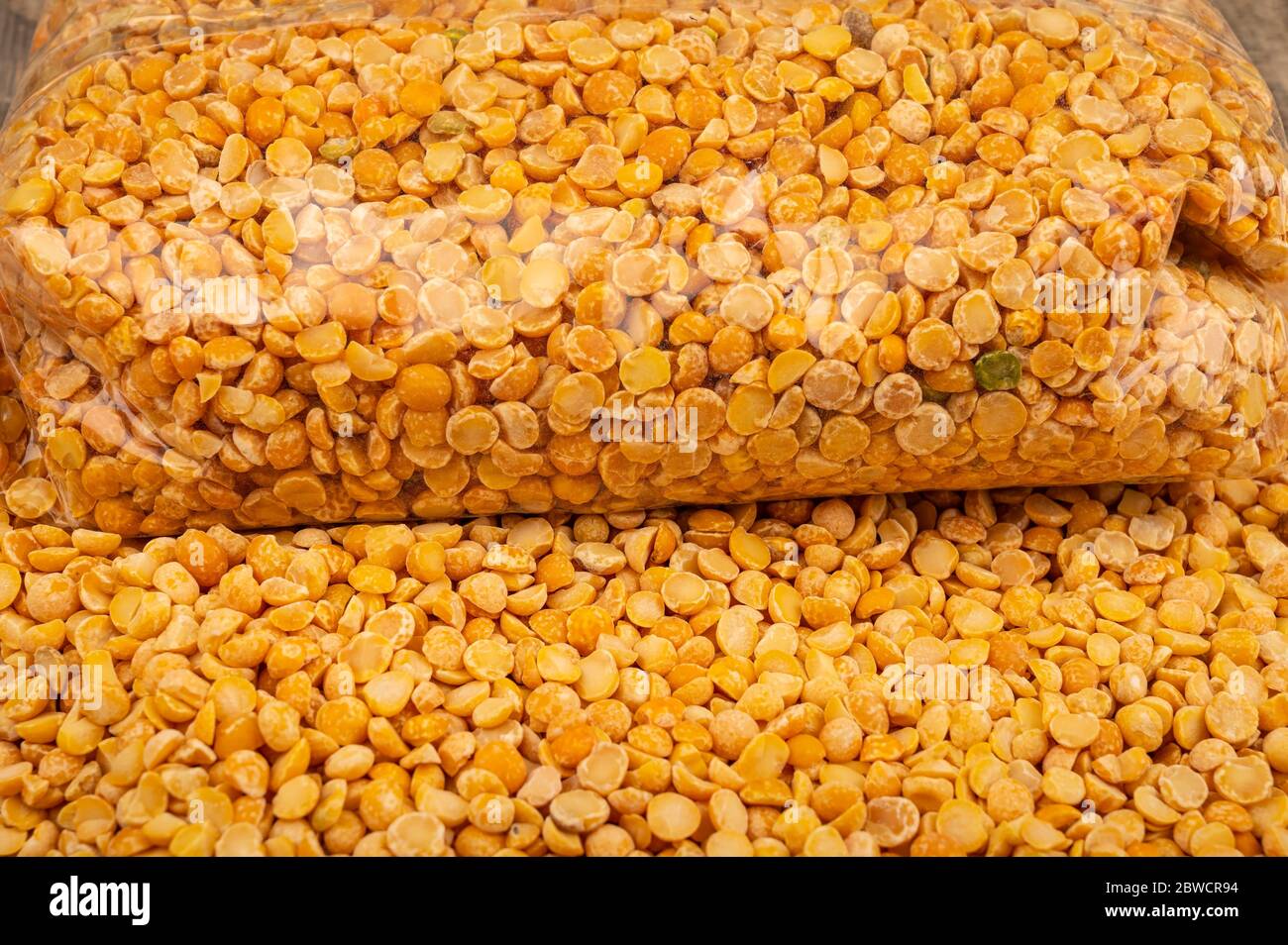 Yellow split peas in a plastic bag and cereal in bulk on a background ...