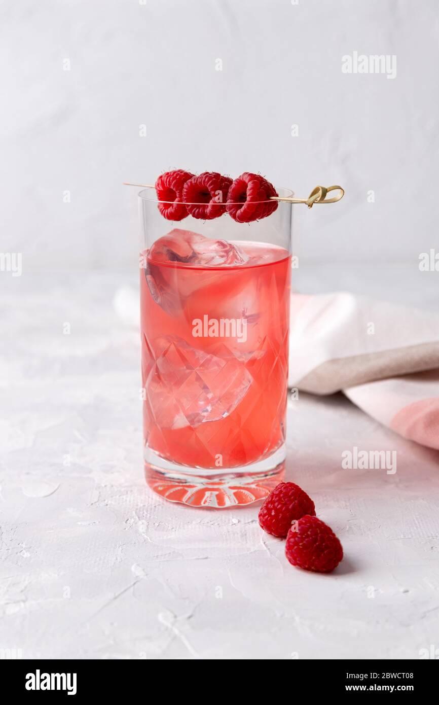 Pink rose iced cocktail with raspberry in crystal glass on table Stock ...
