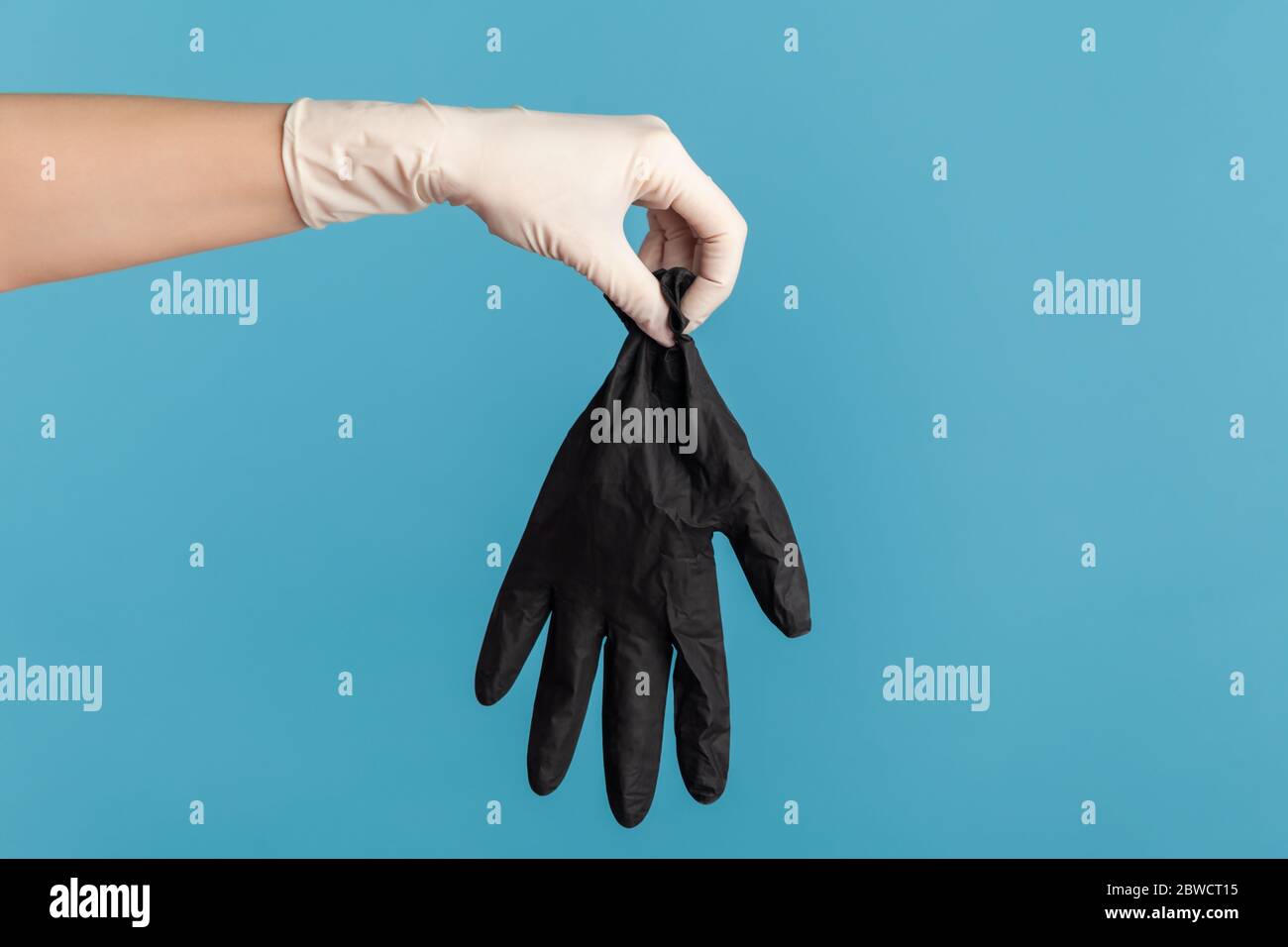 Profile side view closeup of human hand in white surgical gloves ...