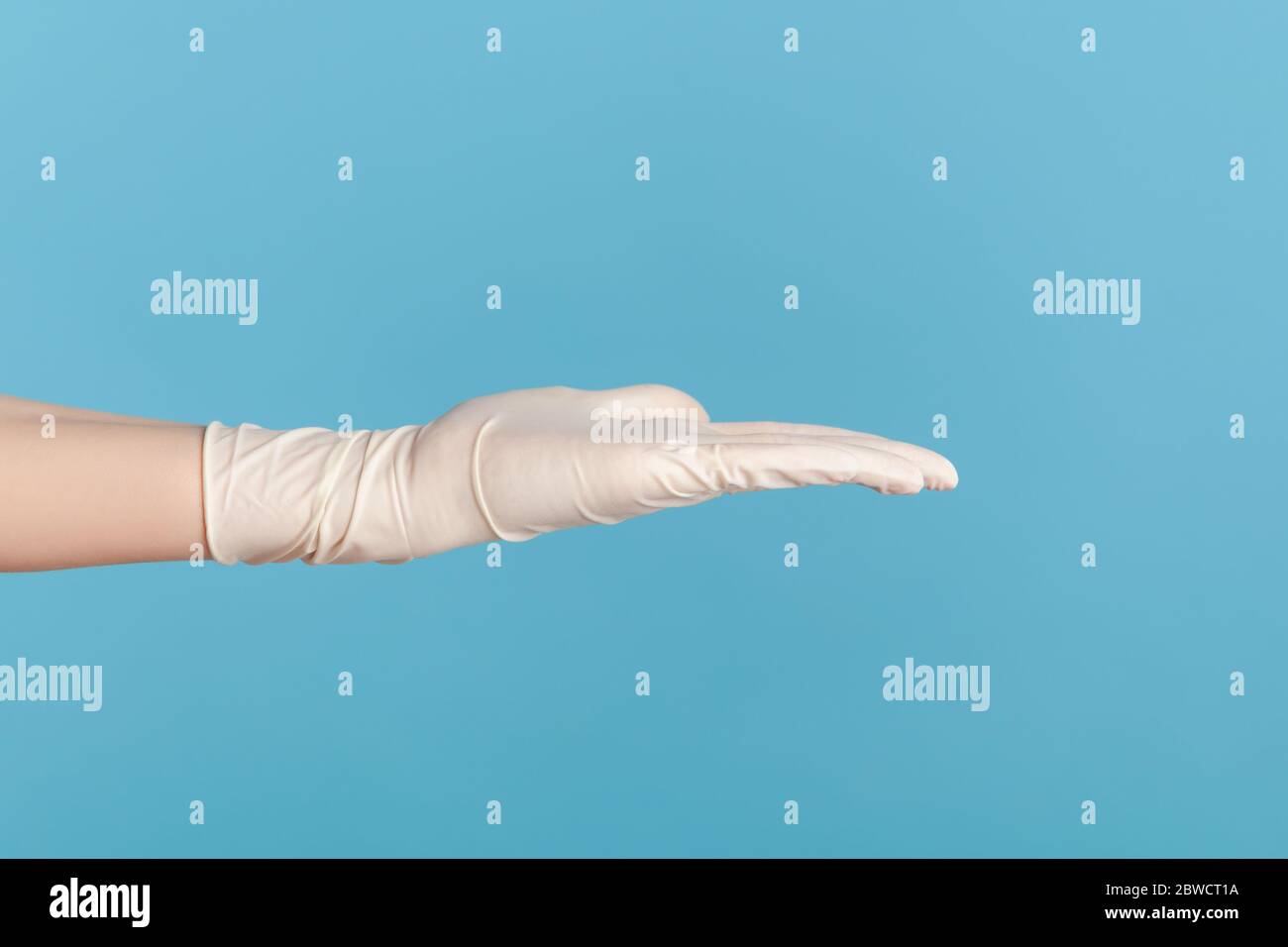 Profile side view closeup of human hand in white surgical gloves ...