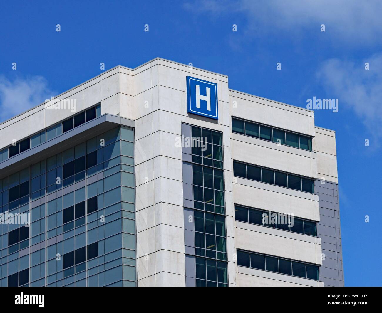 large modern building with blue letter H sign for hospital Stock Photo ...