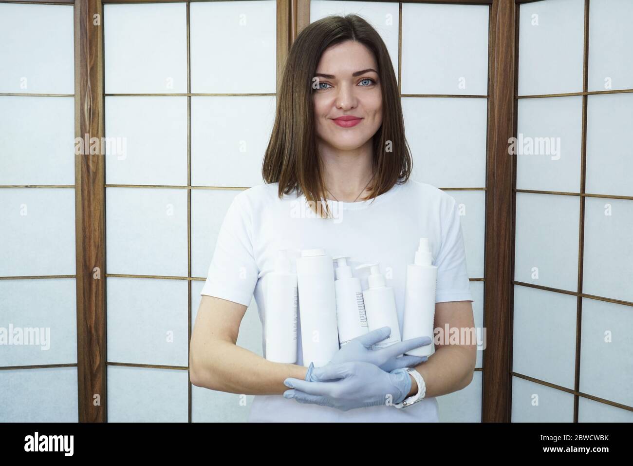 Master holds set of cosmetics - white bottles - Beautiful woman master ...