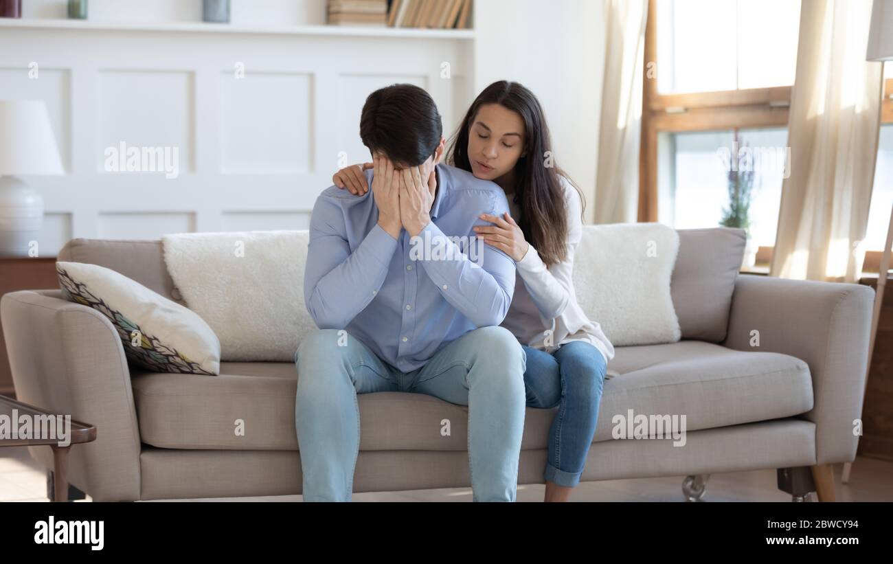 Young woman hug comfort upset husband at home Stock Photo - Alamy