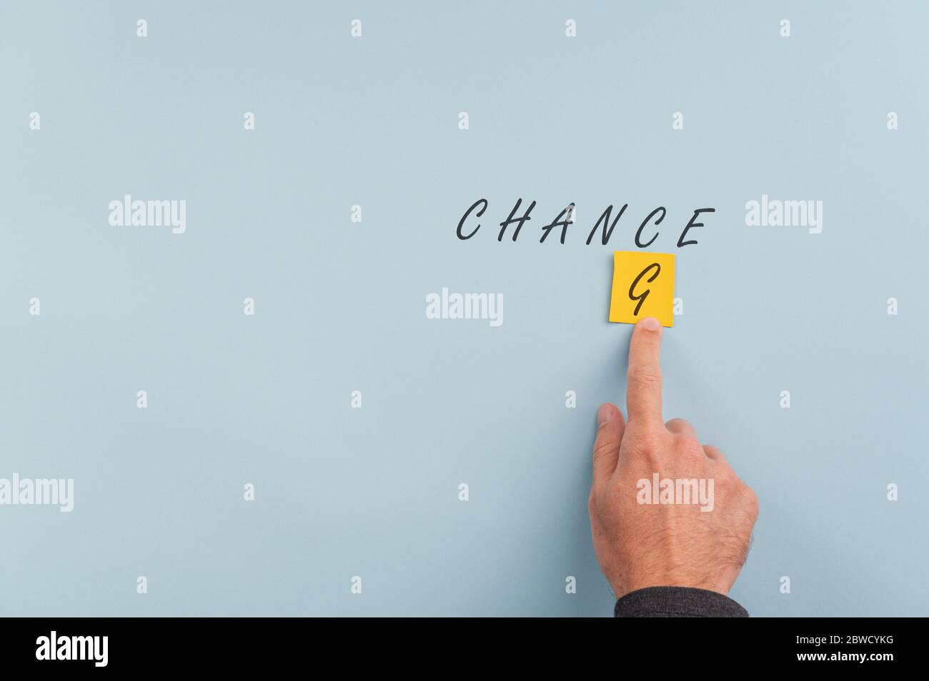 Male hand changing the word Change into Chance. Over blue background ...