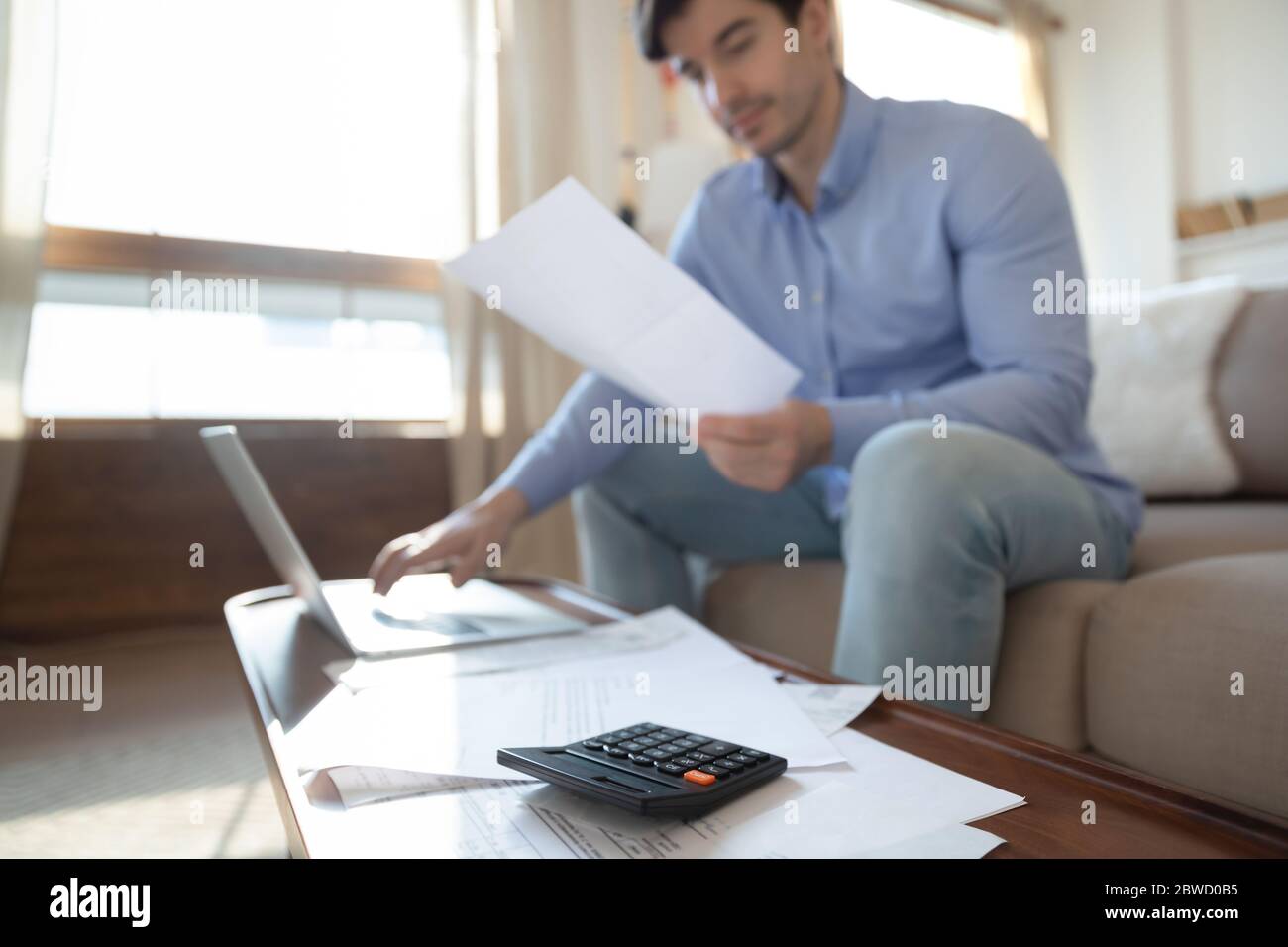Paying bills man calculator hi-res stock photography and images - Alamy