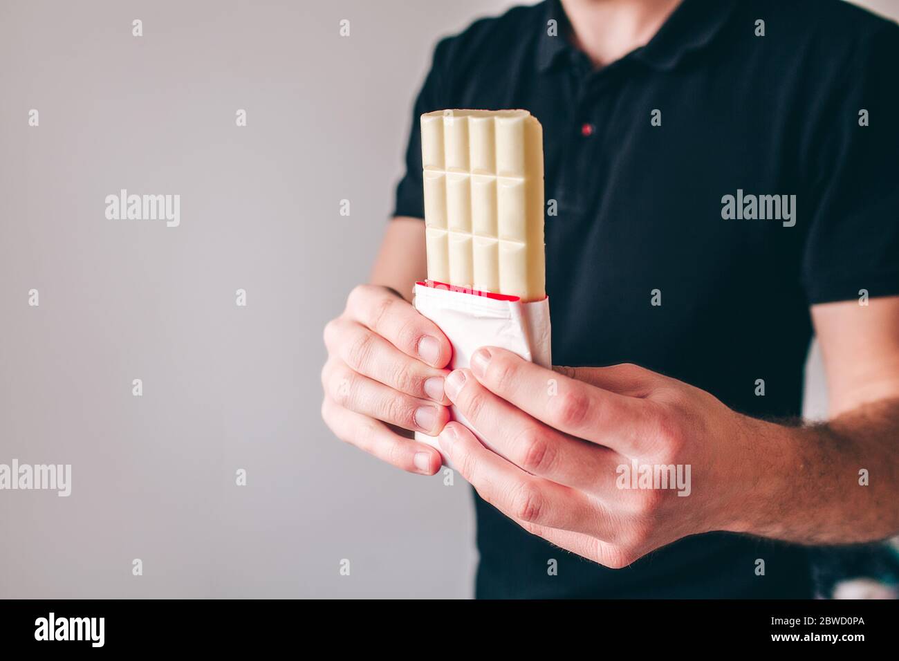 Young man isolated over background. Cut view of guy holding chocolate ...