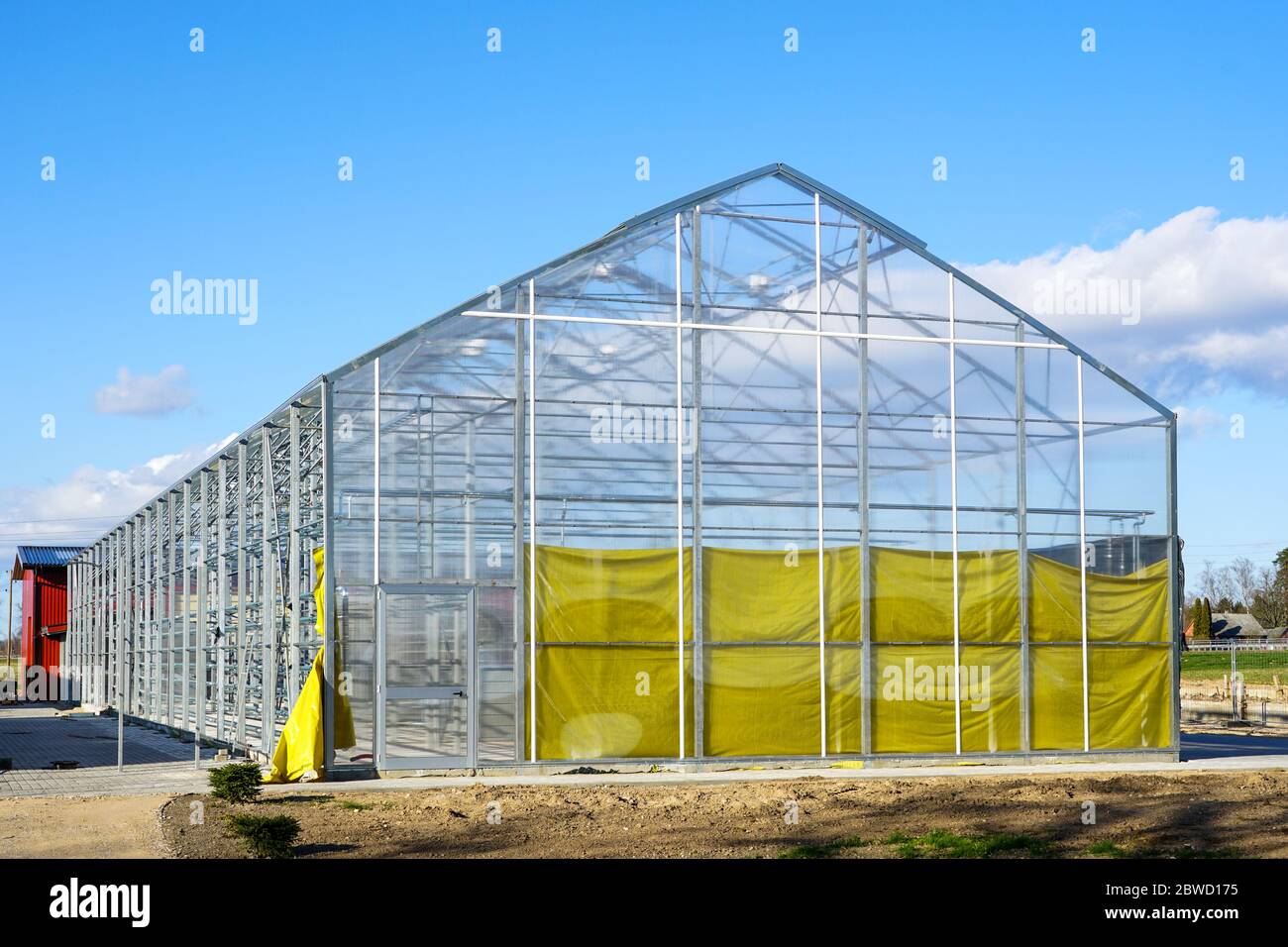 construction of a new large greenhouse with a metal frame in a rural ...
