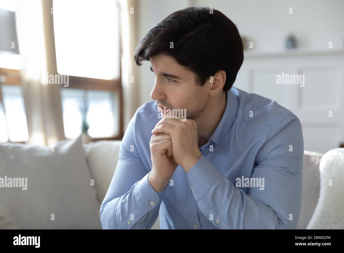 Upset young man look in distance thinking at home Stock Photo - Alamy