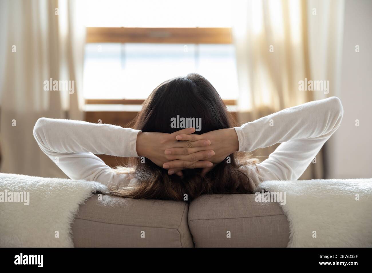 Back view of woman sit relax on sofa at home Stock Photo - Alamy