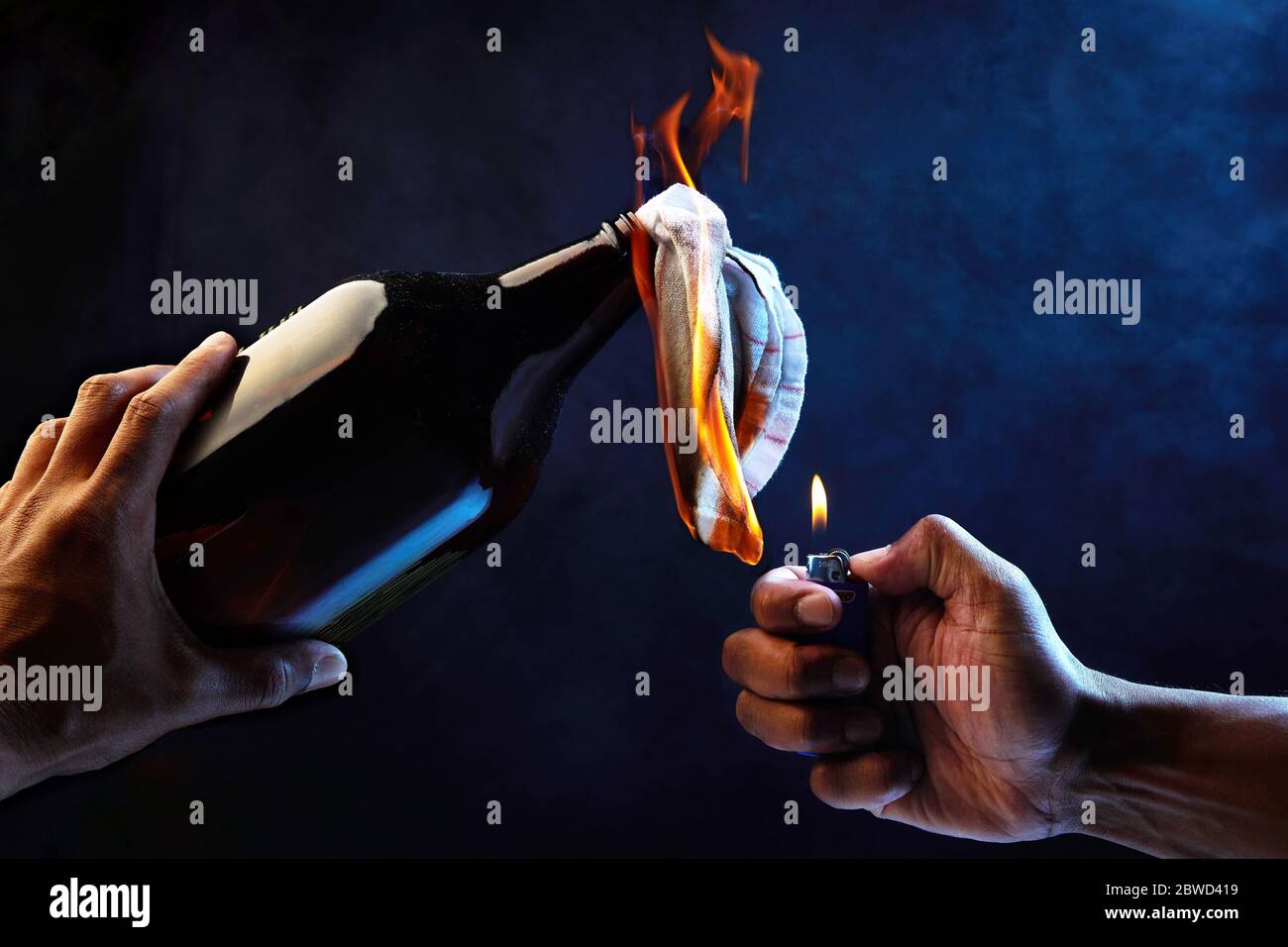 Studio image of a molotov cocktail being set on fire with blue smoke in ...