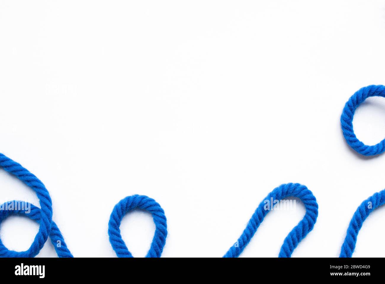 top view of blue wool thread on white background Stock Photo - Alamy