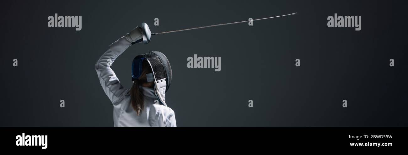 Back view of fencer training with rapier isolated on black, panoramic ...