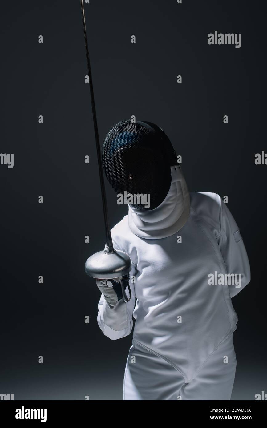Fencer in fencing mask holding rapier isolated on black Stock Photo - Alamy