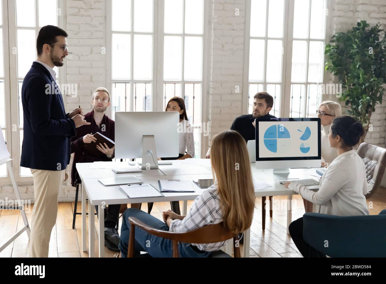 Confident male team leader explaining marketing strategy to multiracial ...