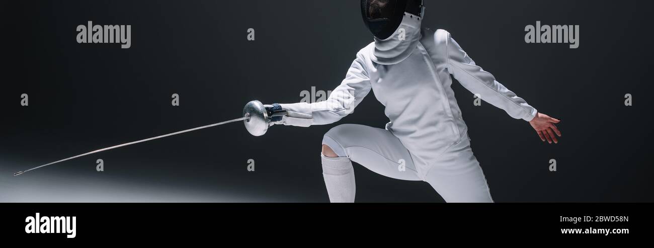 Horizontal image of fencer training with rapier on black background ...