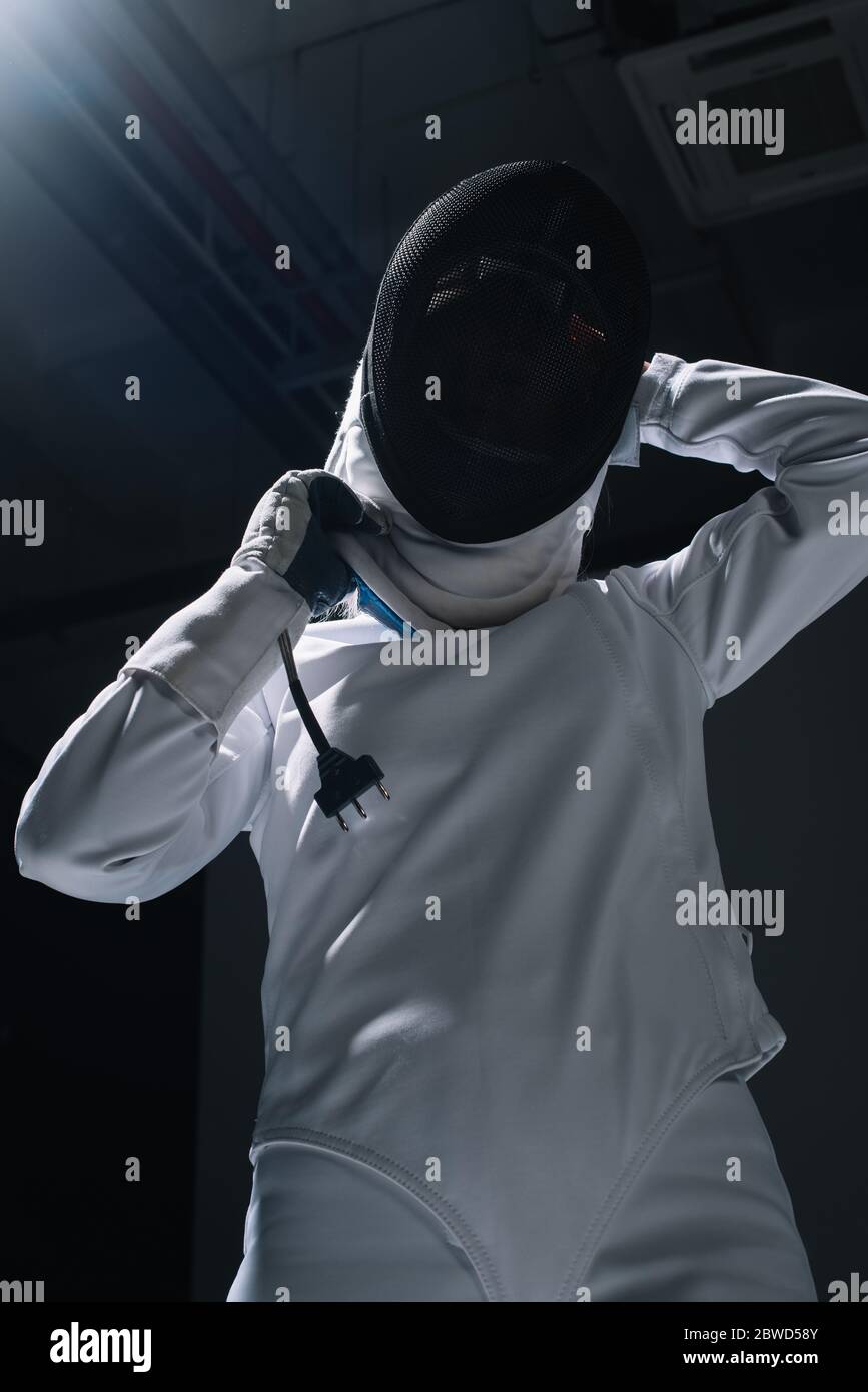Low angle view of fencer putting on fencing mask Stock Photo - Alamy