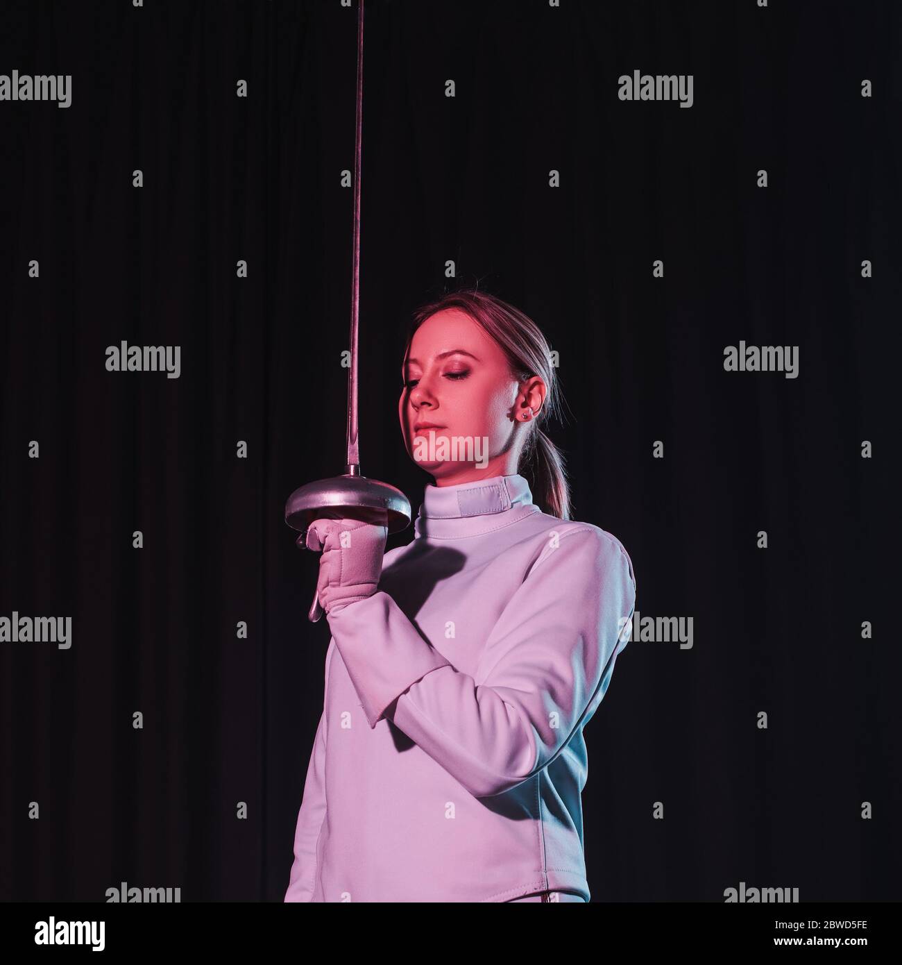 Beautiful fencer holding rapier isolated on black Stock Photo - Alamy