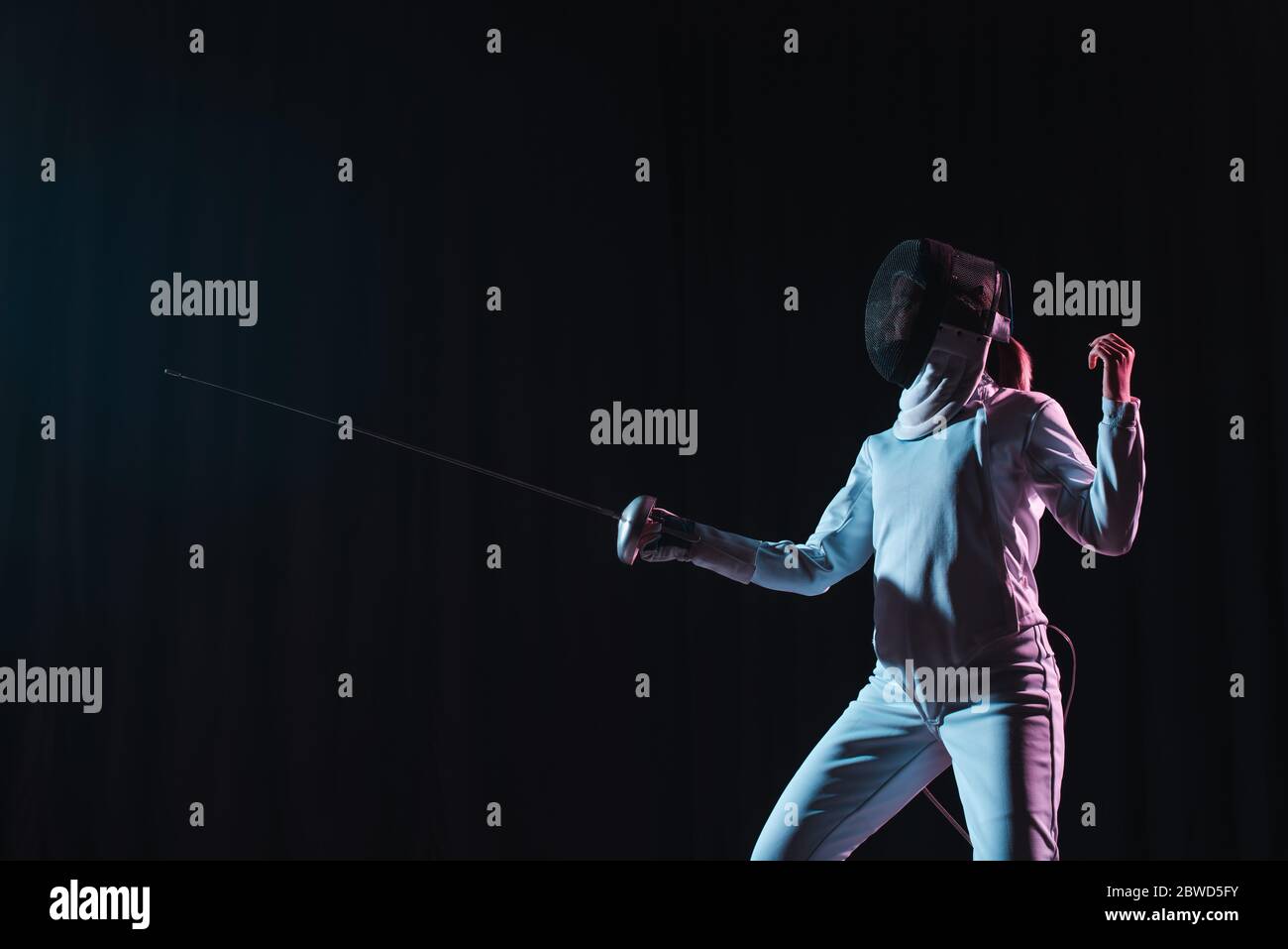 Swordswoman fencing with rapier isolated on black Stock Photo - Alamy