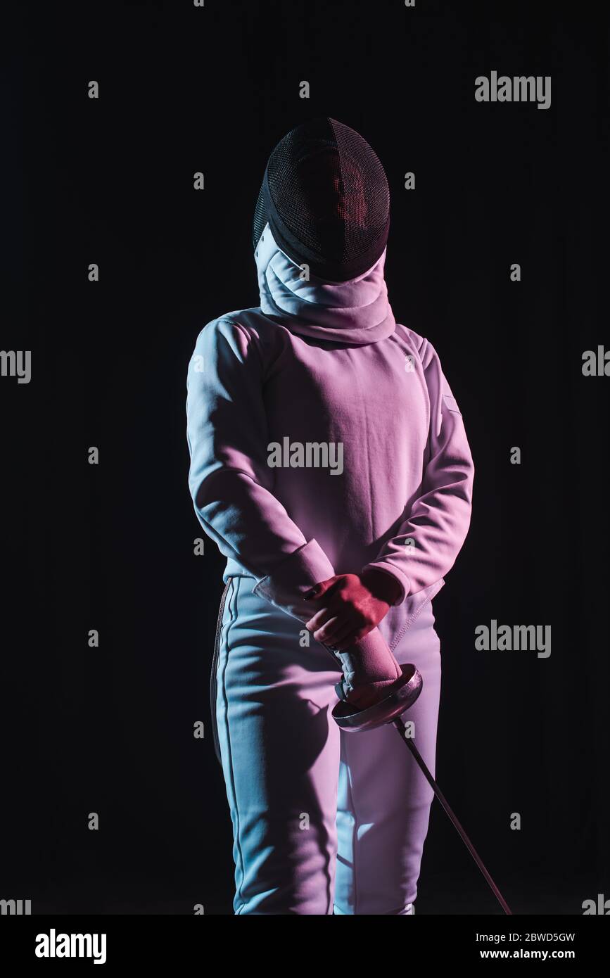 Fencer in fencing mask holding rapier isolated on black Stock Photo - Alamy