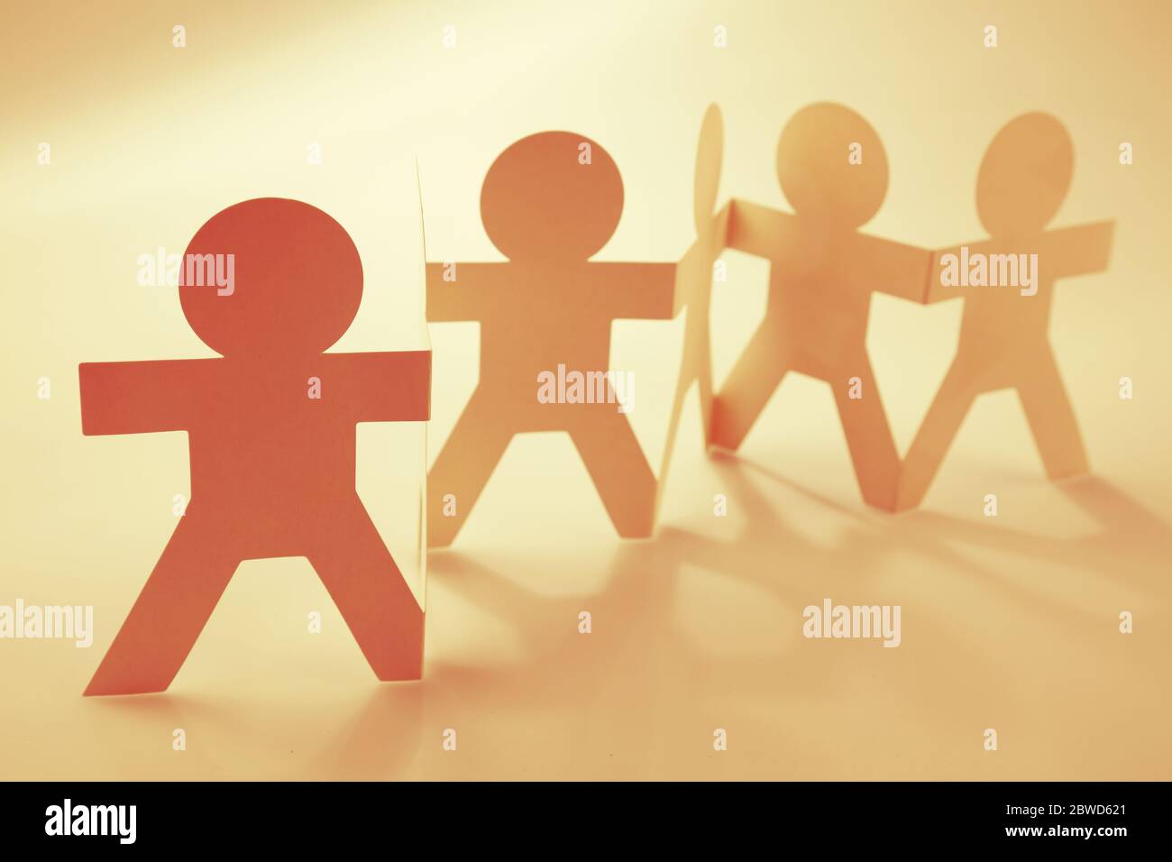 Paper chain team holding hands. Teamwork. Partnership Stock Photo - Alamy